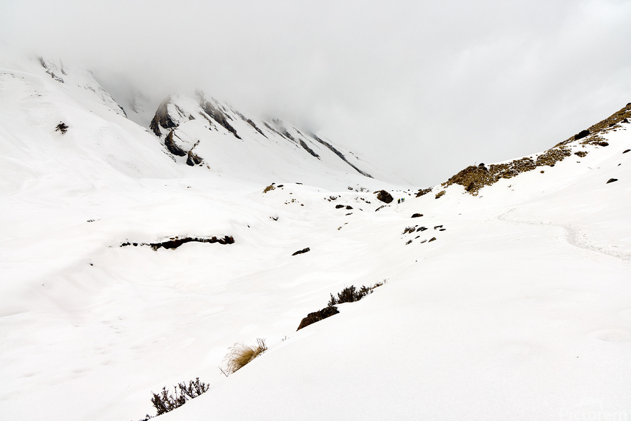 Trekkers navigate a snow covered trail in the Himalayas en route to ...