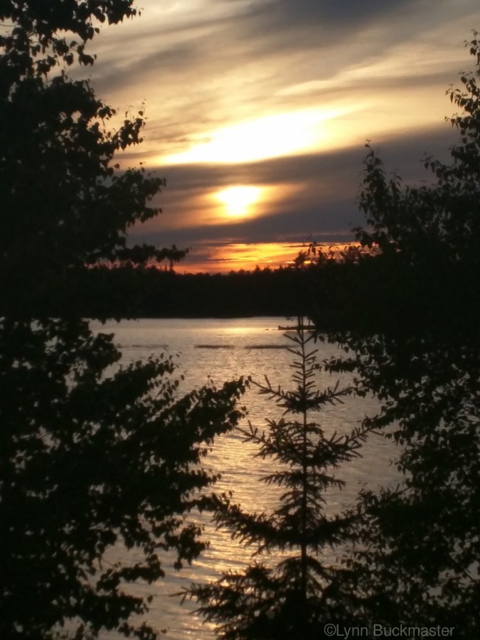 Sunset from the lake house by Lynn Buckmaster Wall Art