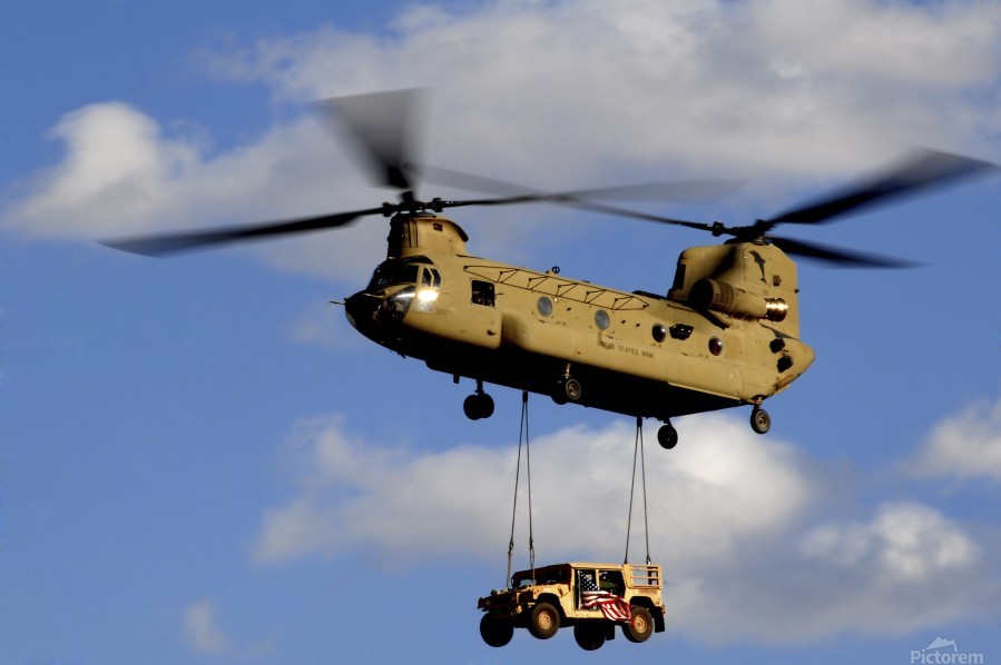 A U.S. Army CH-47 Chinook helicopter transports a Humvee. by StocktrekImages Wall Art